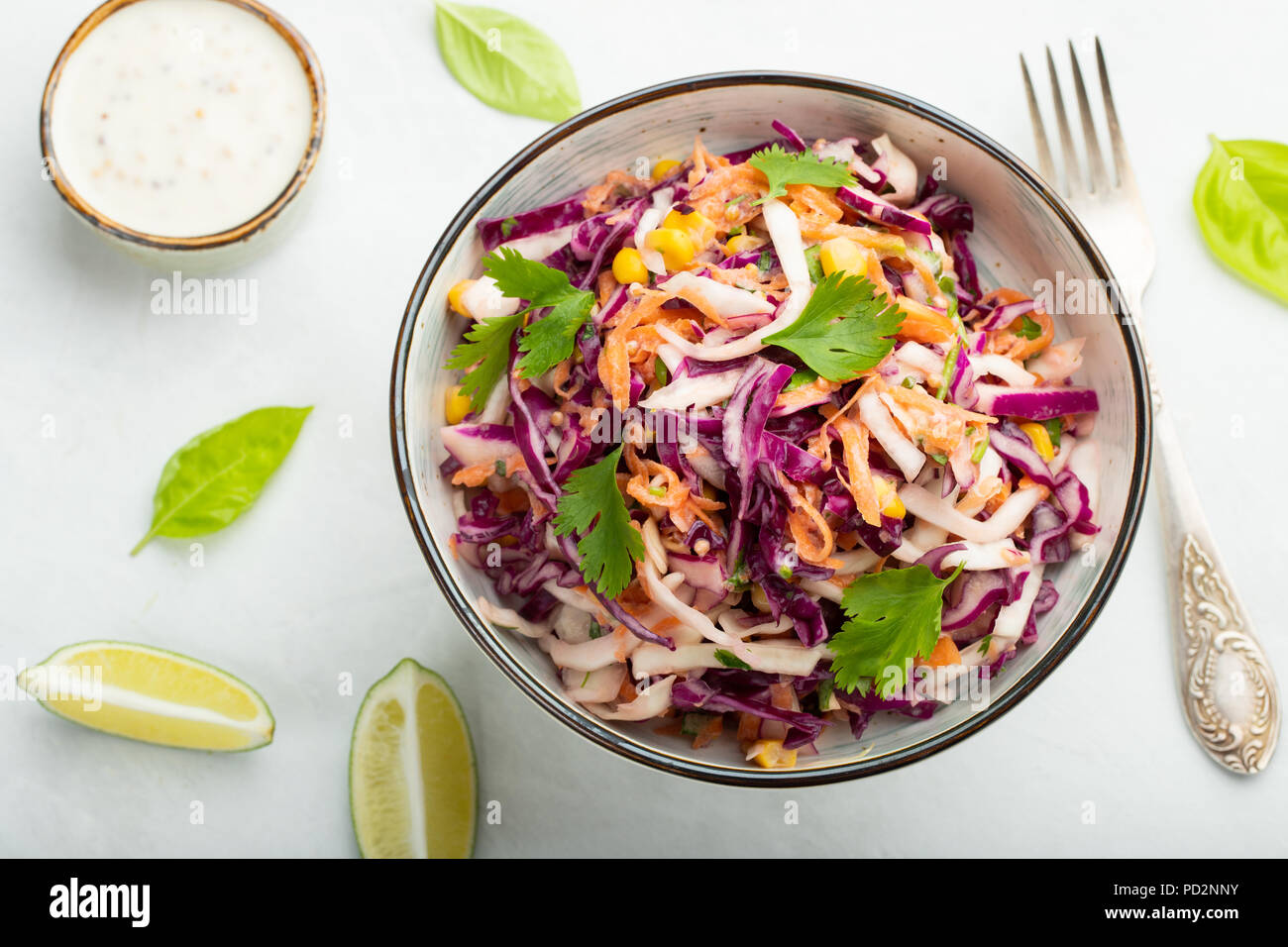 Purple cabbage and carrot salad with mayonnaise in a white bowl on a ...