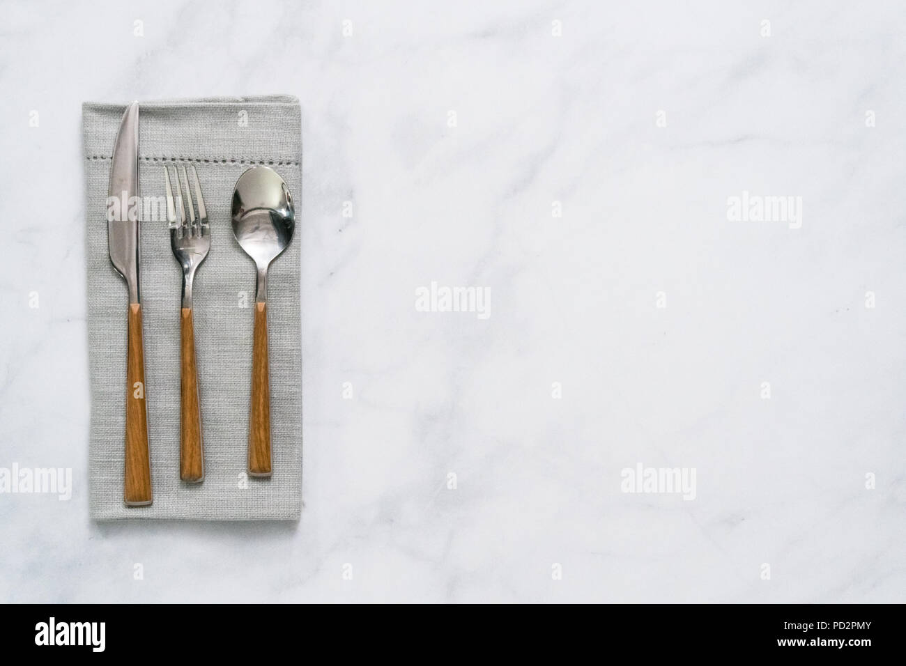 Set of dining silverware on linen dinner napkin Stock Photo - Alamy