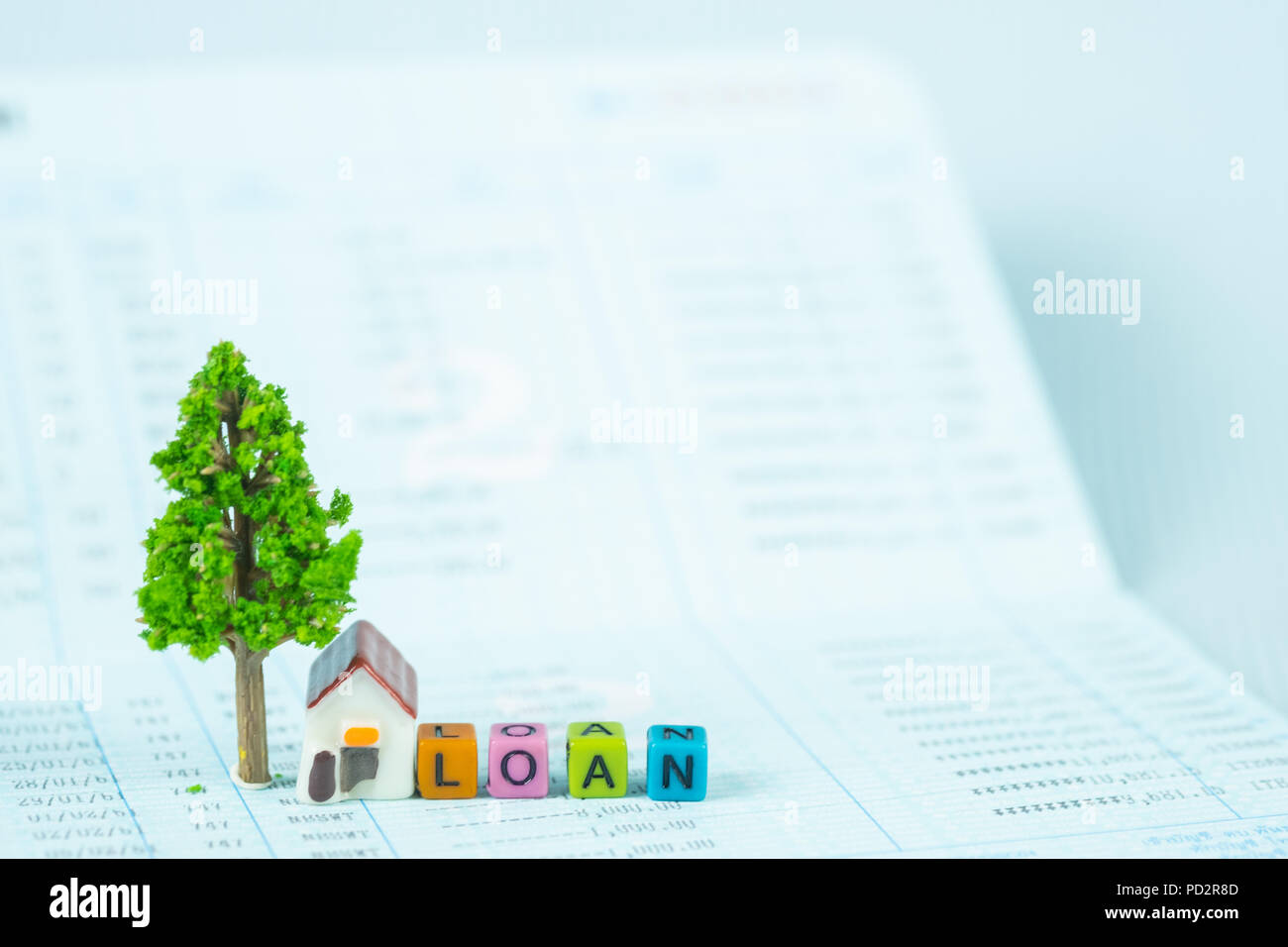 LOAN text and small model house and little tree with notebook, savings ...