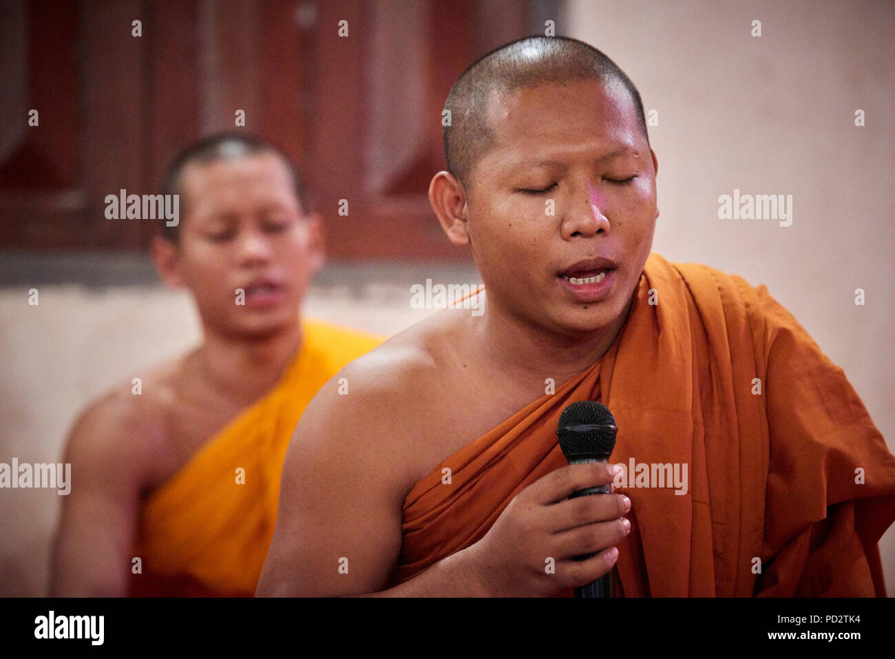 A Buddhist monk chanting with his eyes closed during a ceremony in one ...