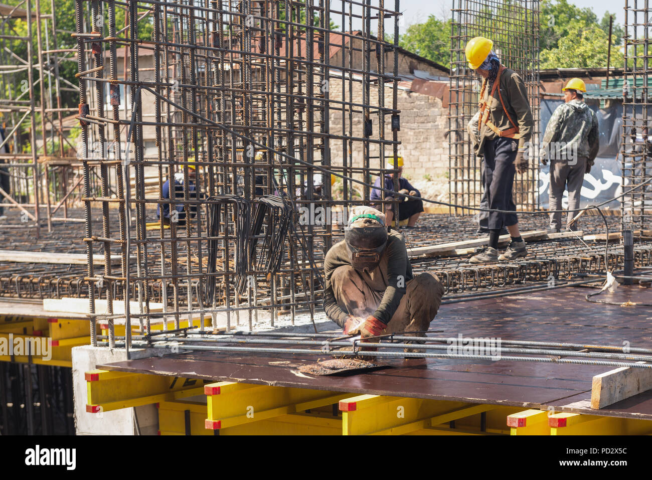 workers at the construction site produce welding work to fill the ...