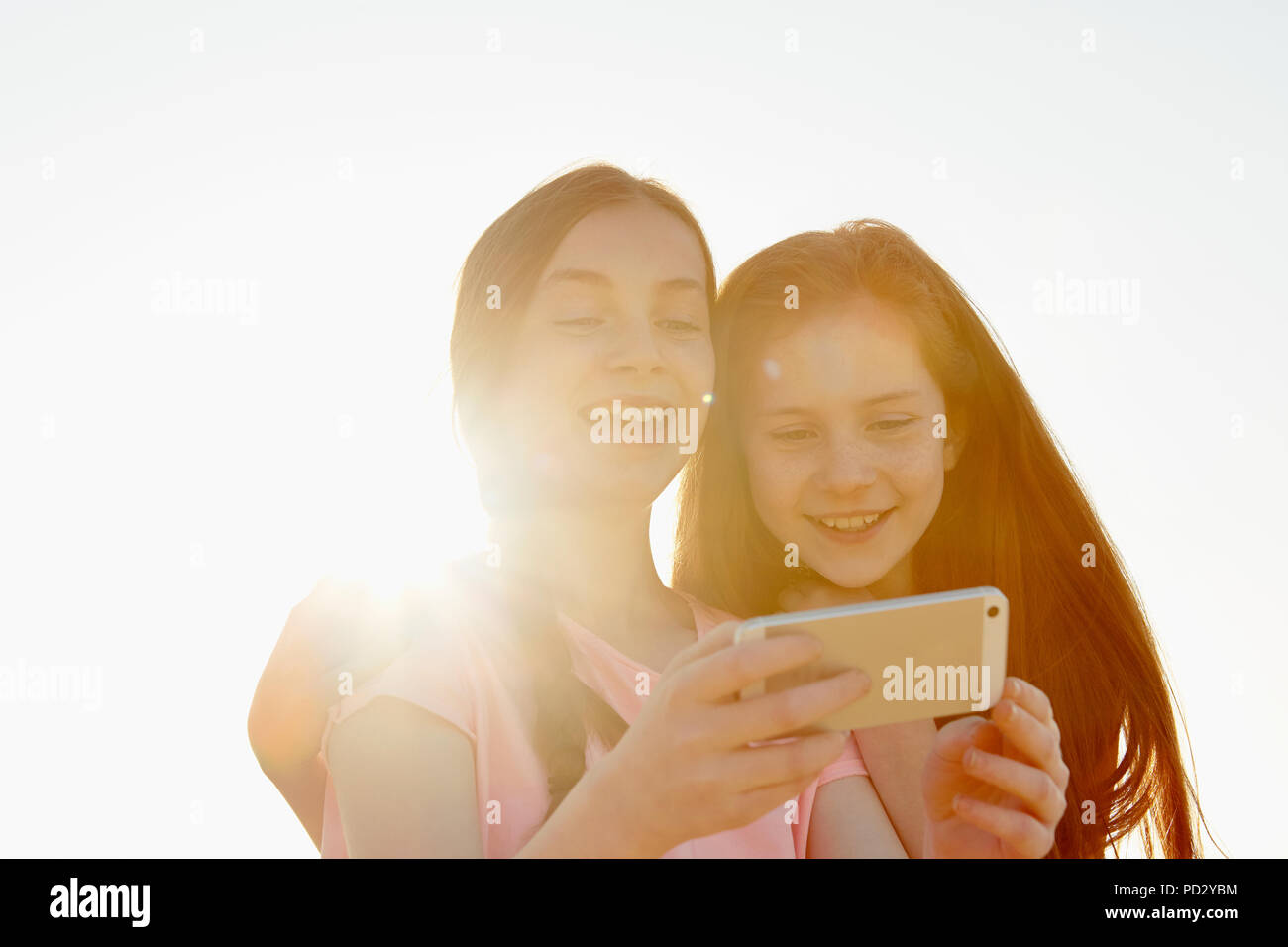 Best friends using smartphone together Stock Photo - Alamy