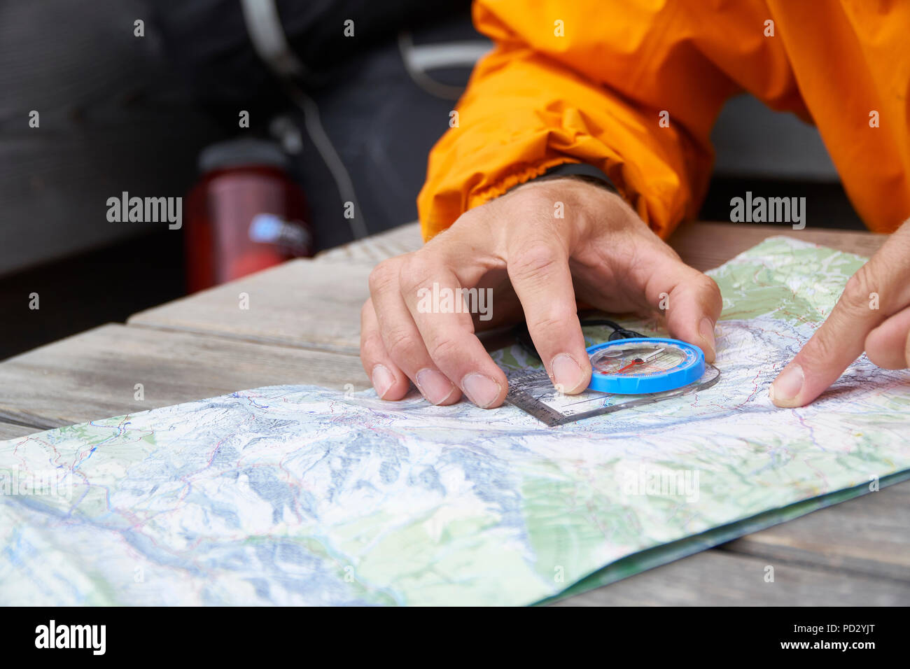 Hiker reading map with compass Stock Photo - Alamy