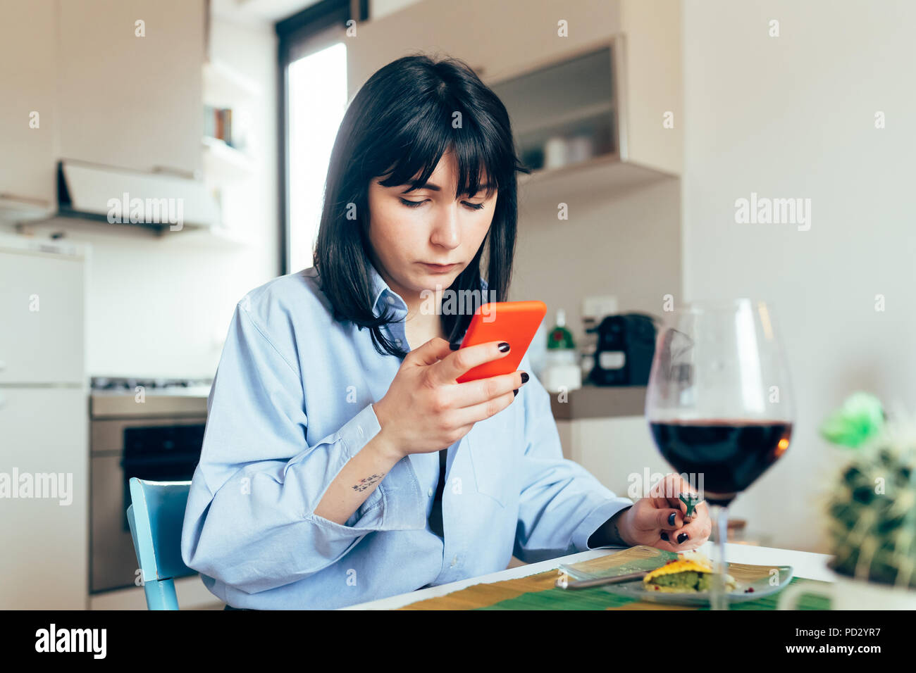 Woman alone smartphone sitting texting hi-res stock photography and ...