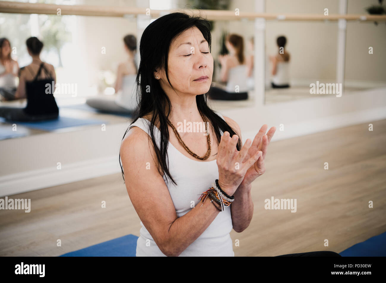 Woman in yoga pose, mirror in background Stock Photo - Alamy