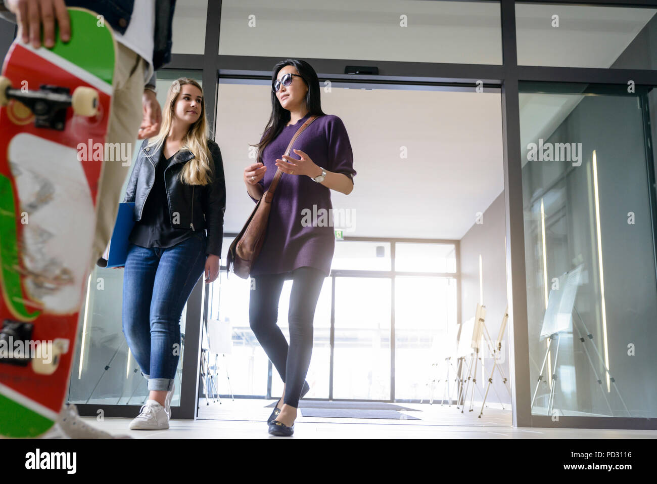 Students entering college building by glass doors Stock Photo - Alamy