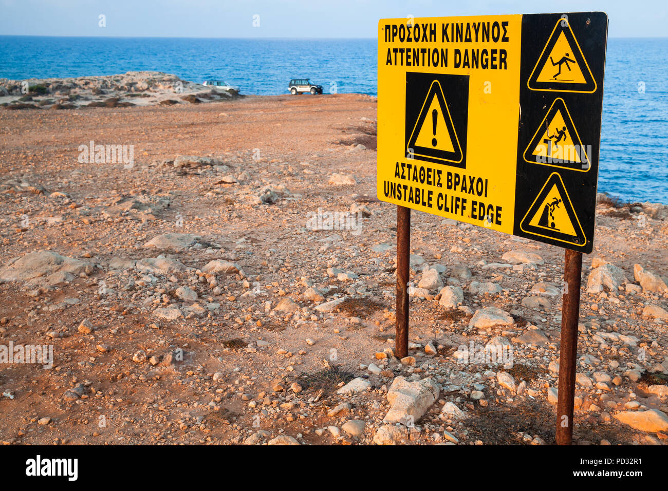 Attention, danger, unstable cliff edge. Warning sign on the coast of ...
