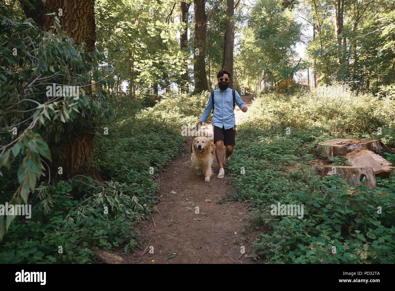 Handsome man walking his dog in outdoors Stock Photo - Alamy