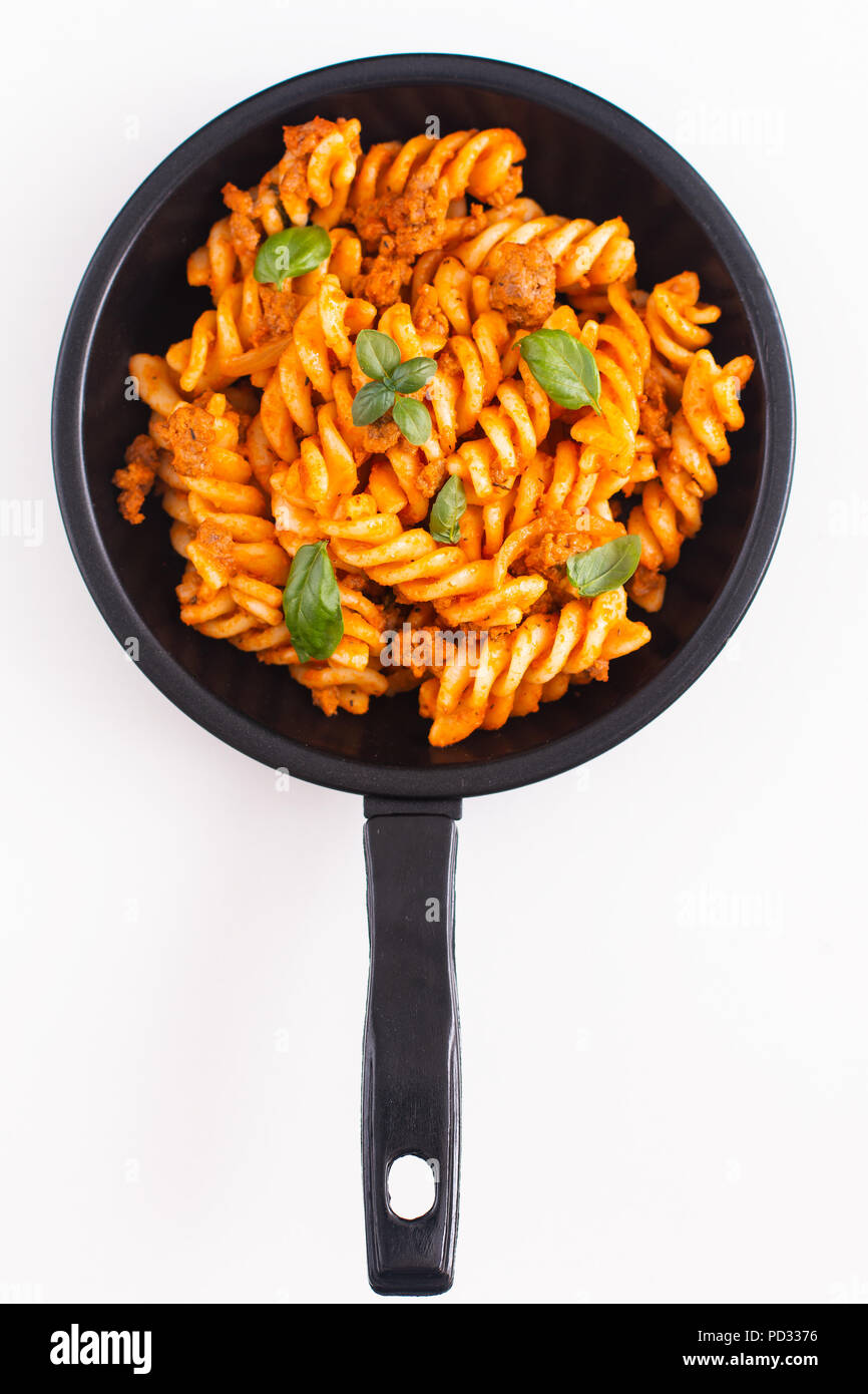 Homemade Fusilli pasta with bolognese sauces in the black iron pan on ...