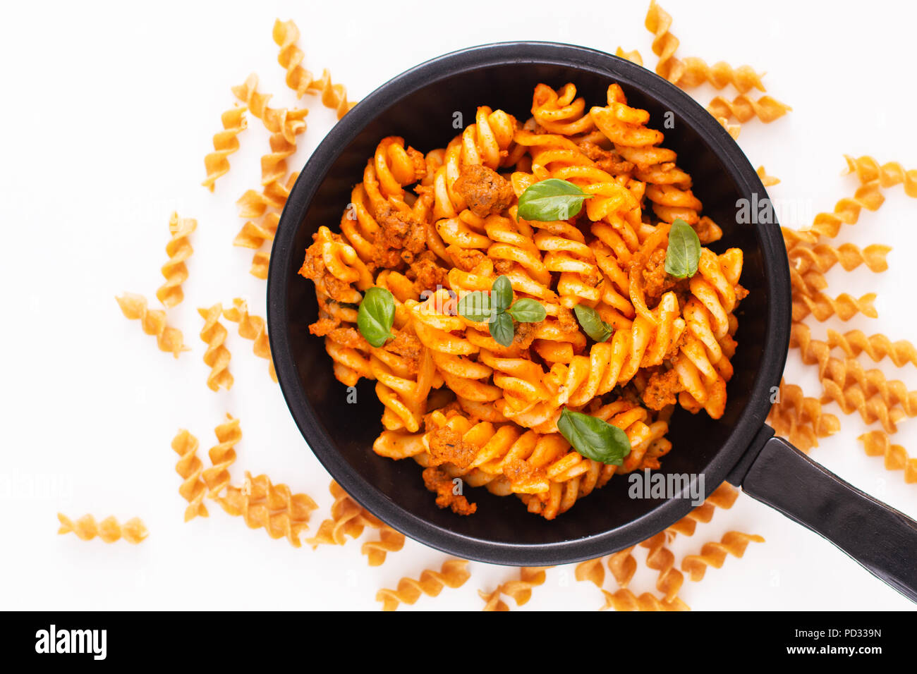 Homemade Fusilli pasta with bolognese sauces in the black iron pan on ...