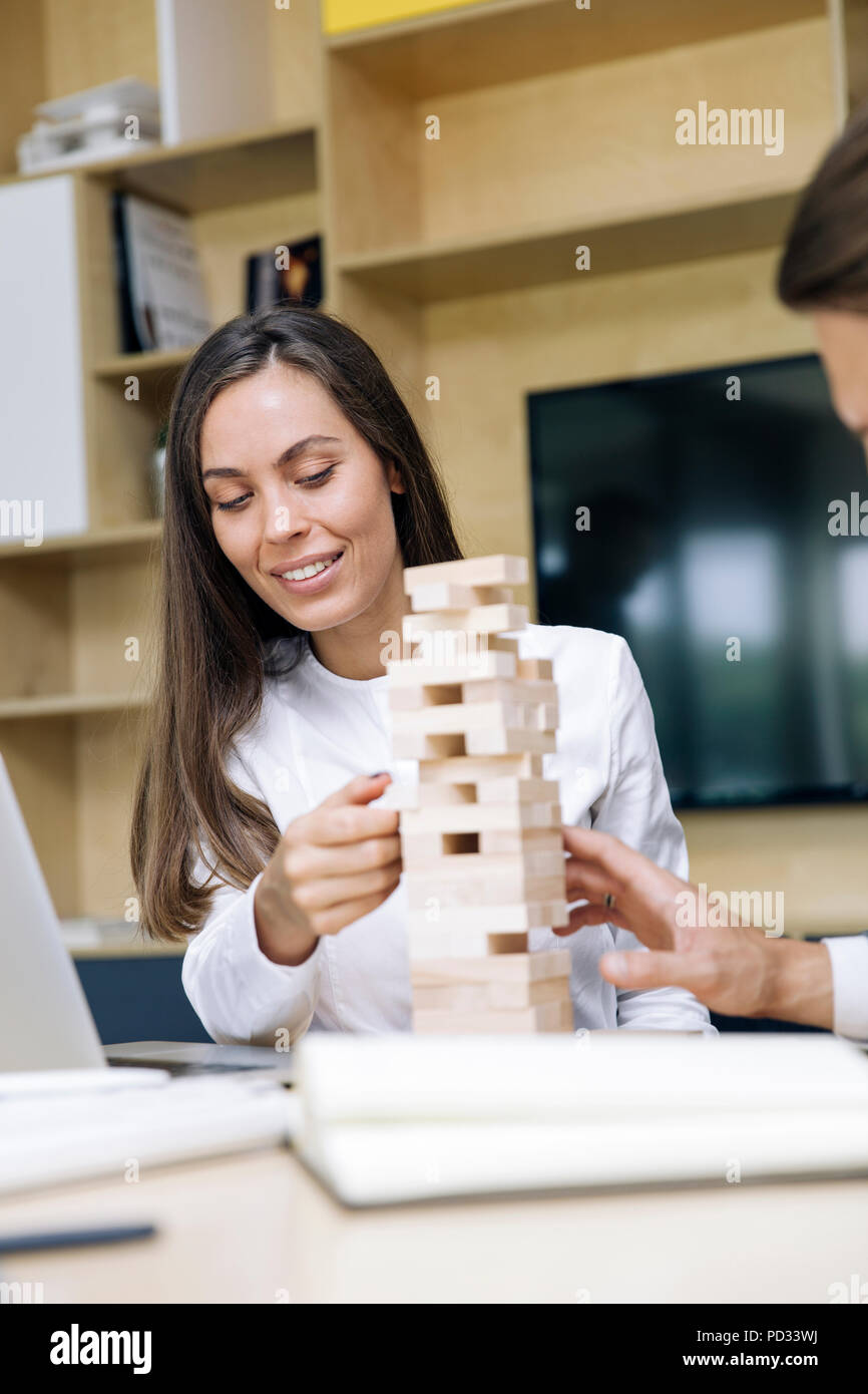 Young business woman build a wooden construction in the office Stock ...
