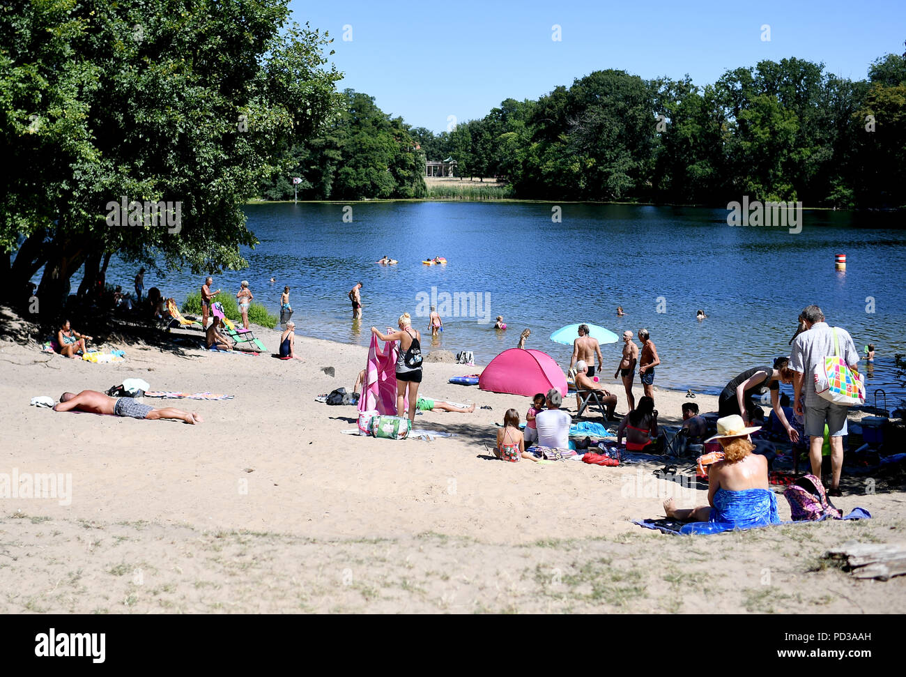 06 August 2018, Berlin, Germany: Families enjoy summer at a bathing spot on Lake Tegel. Photo ...