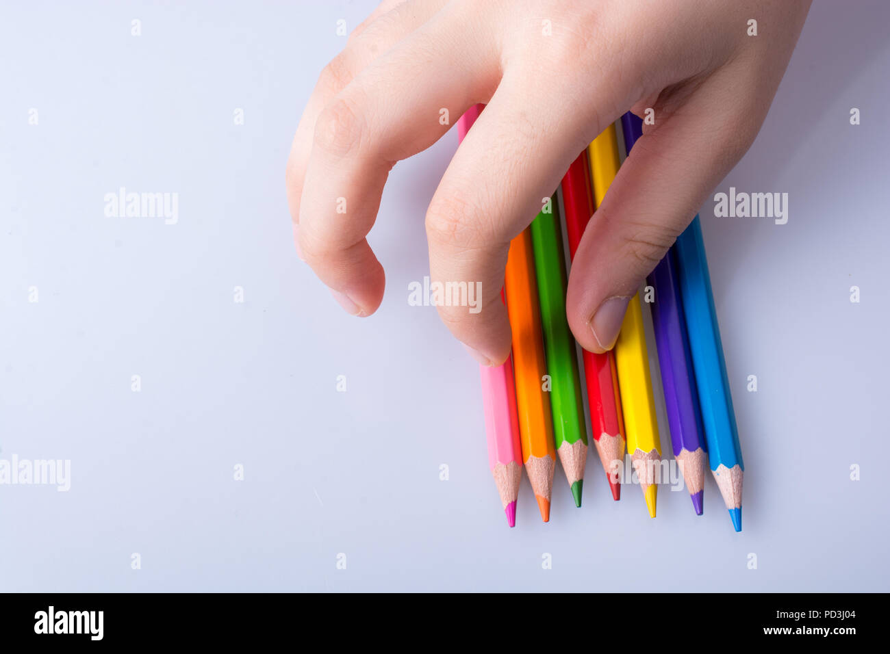 Hand holding color Pencils placed on a white background Stock Photo - Alamy