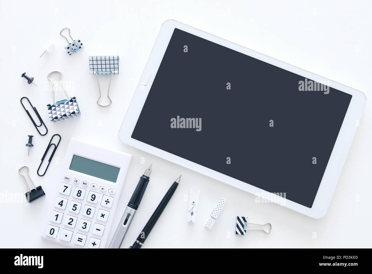 White office desk table with calculator, tablet and other office ...