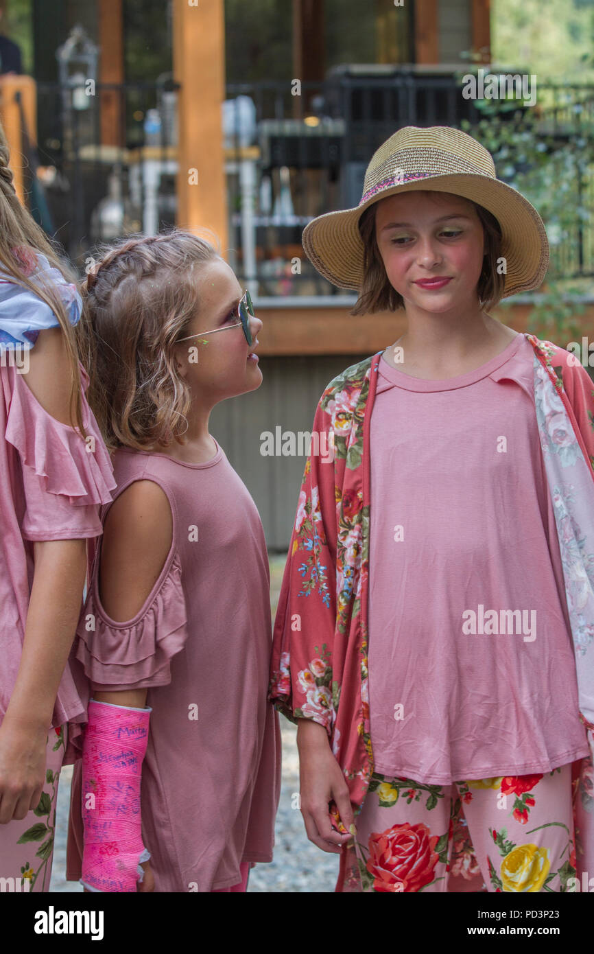 Two young girls, in fashion show, wearing beauriful outfits. 3/4 shot ...