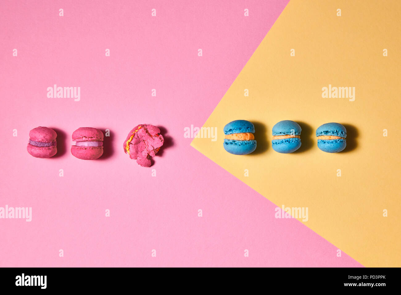 Row of different macaroons on a yellow pink background. Creative layout ...