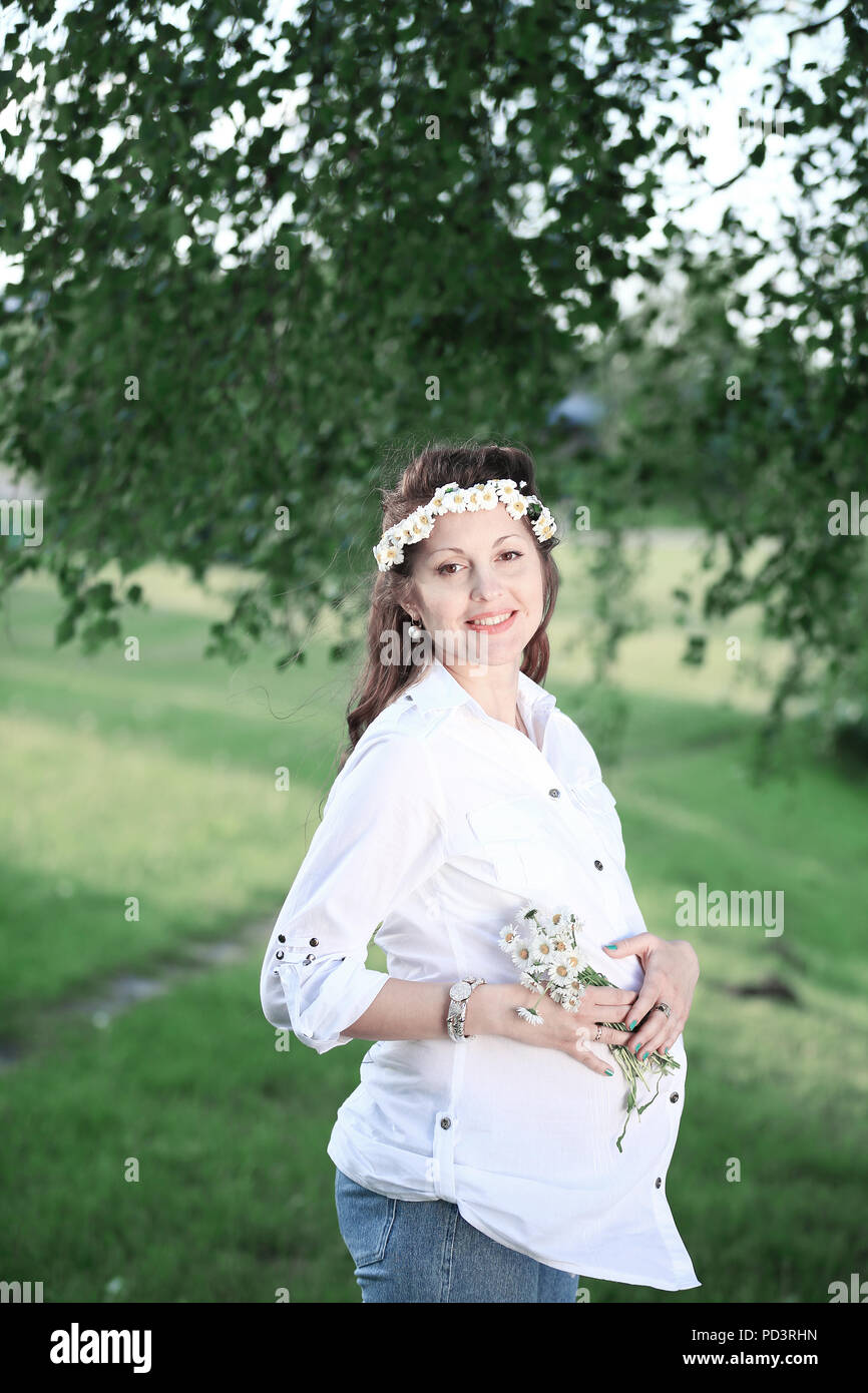 happy pregnant woman in a wreath and a bouquet of wild flowers o Stock ...
