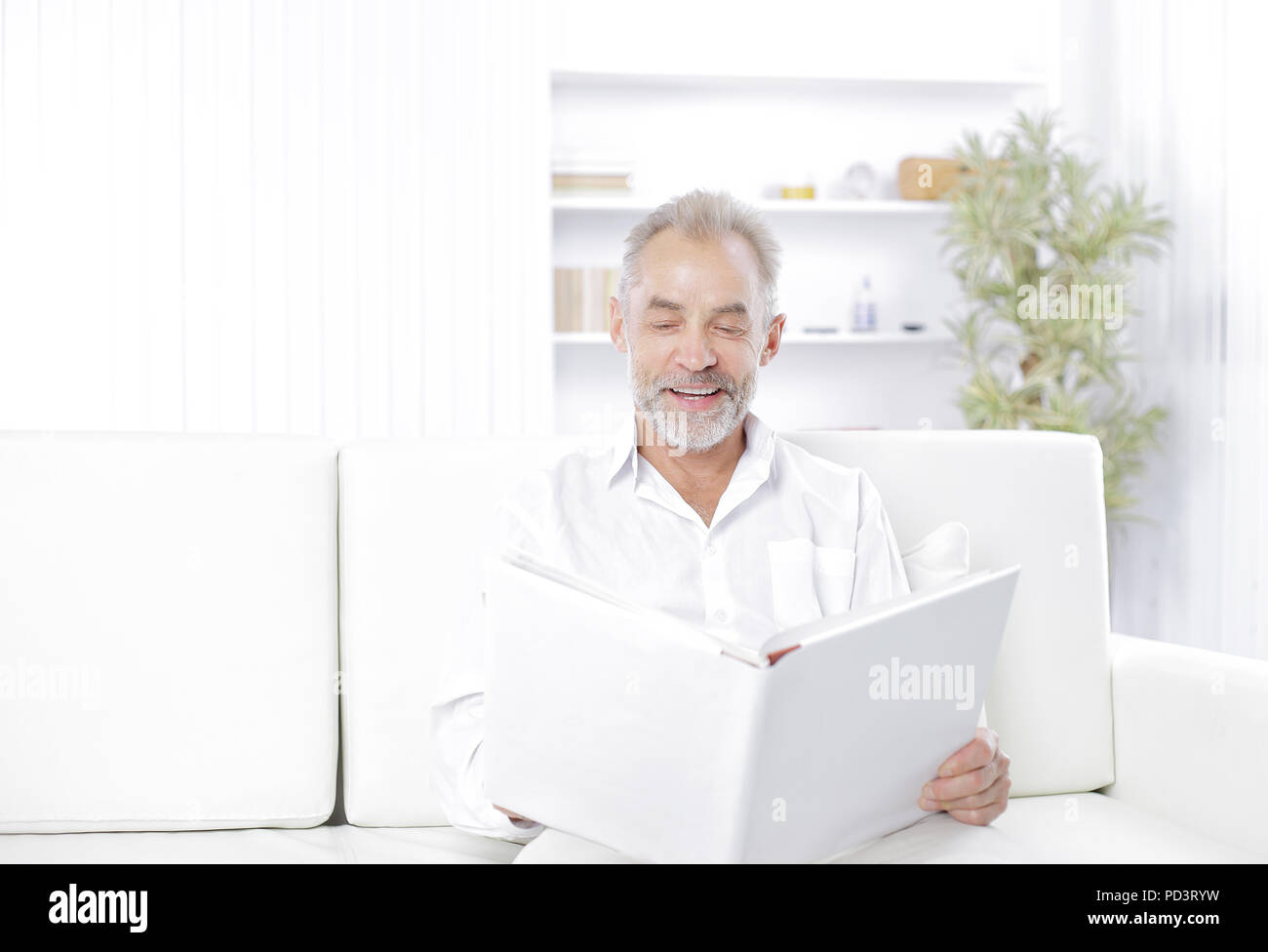 Smiling senior man reading file folder on the couch Stock Photo - Alamy