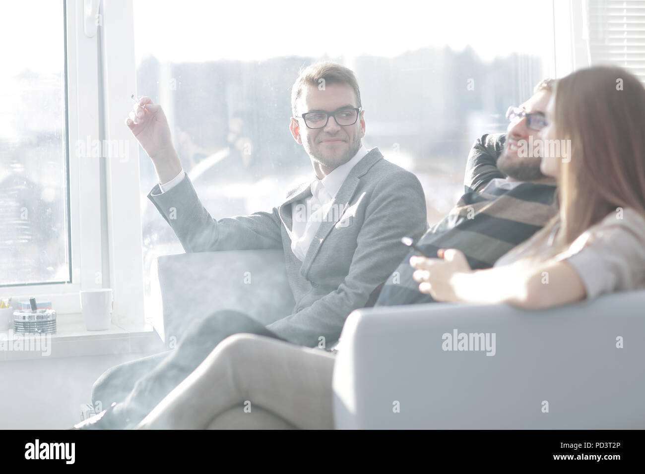 business team sitting on the couch during work break Stock Photo - Alamy