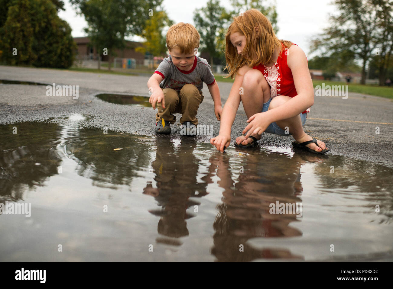 Children playing puddle hi-res stock photography and images - Alamy