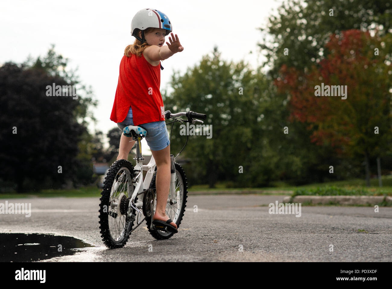 Girl on bicycle stopping in middle of road Stock Photo - Alamy