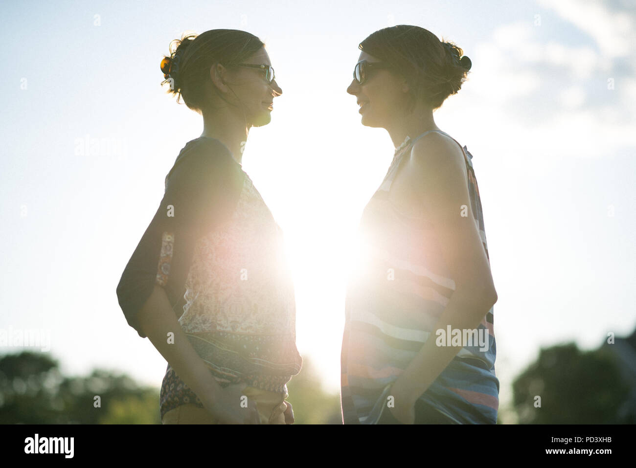 Twin sisters in park at sunset Stock Photo - Alamy