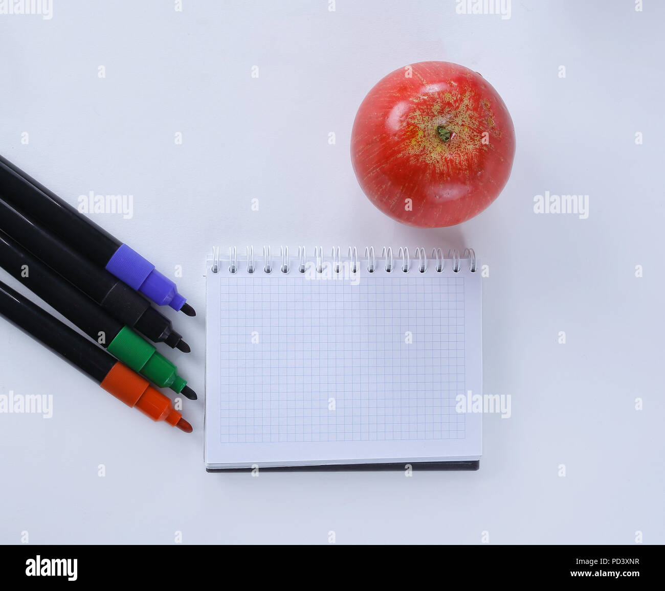 Apple, multicolored markers and open Notepad isolated on white ...