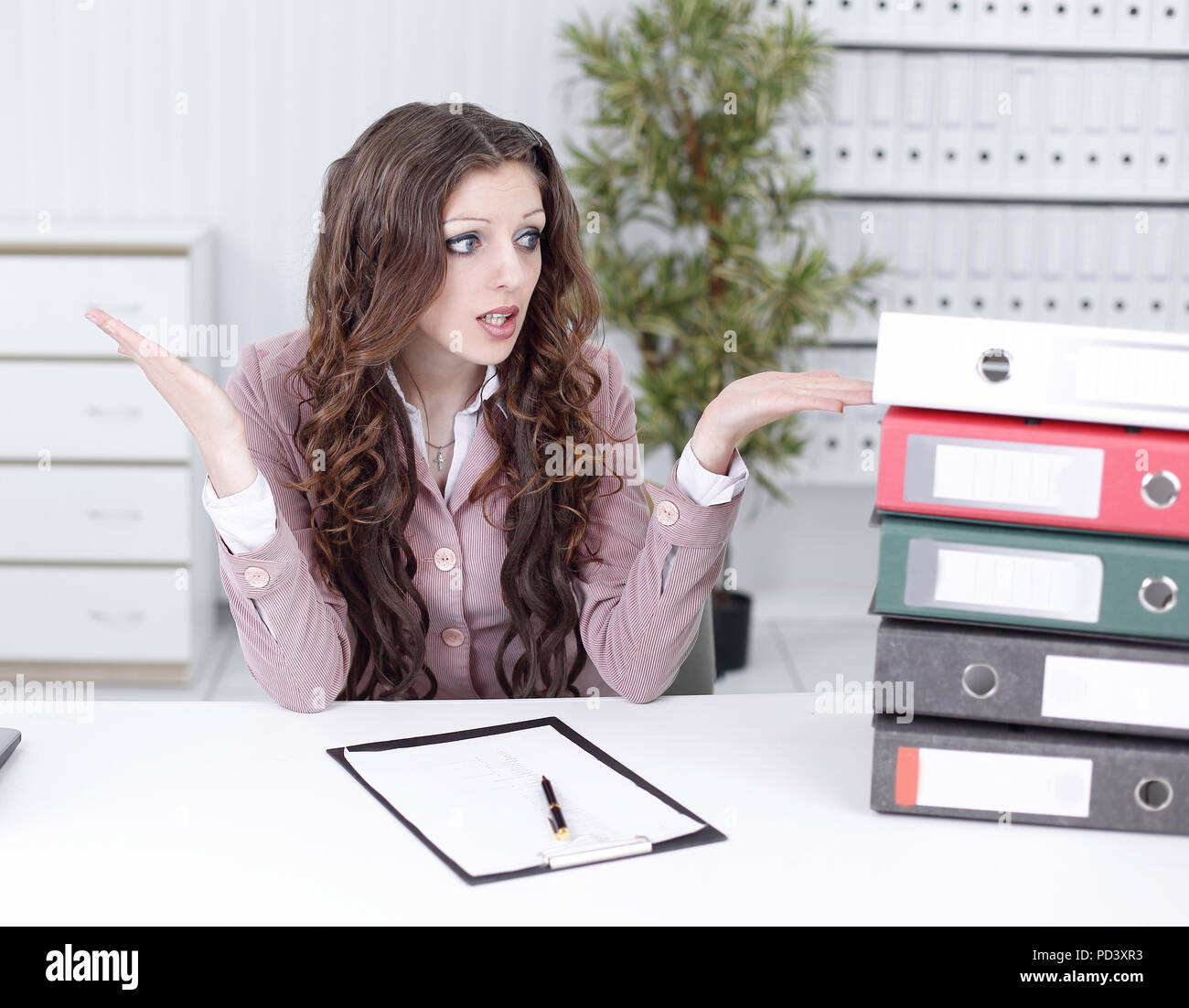 confused business woman looking at a big stack of documents Stock Photo ...