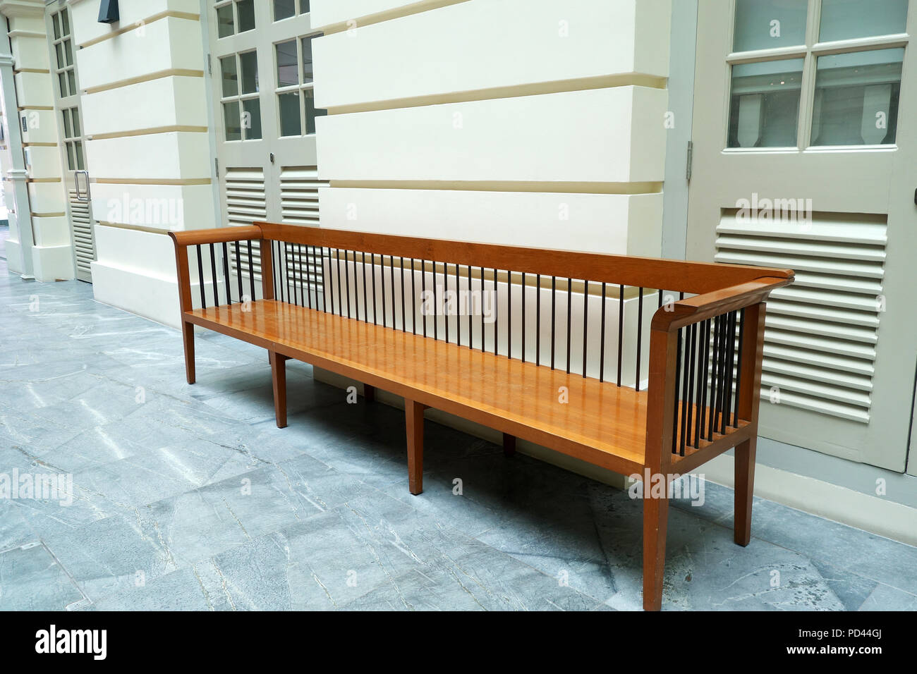 Wooden bench in front of a wall inside a building Stock Photo - Alamy