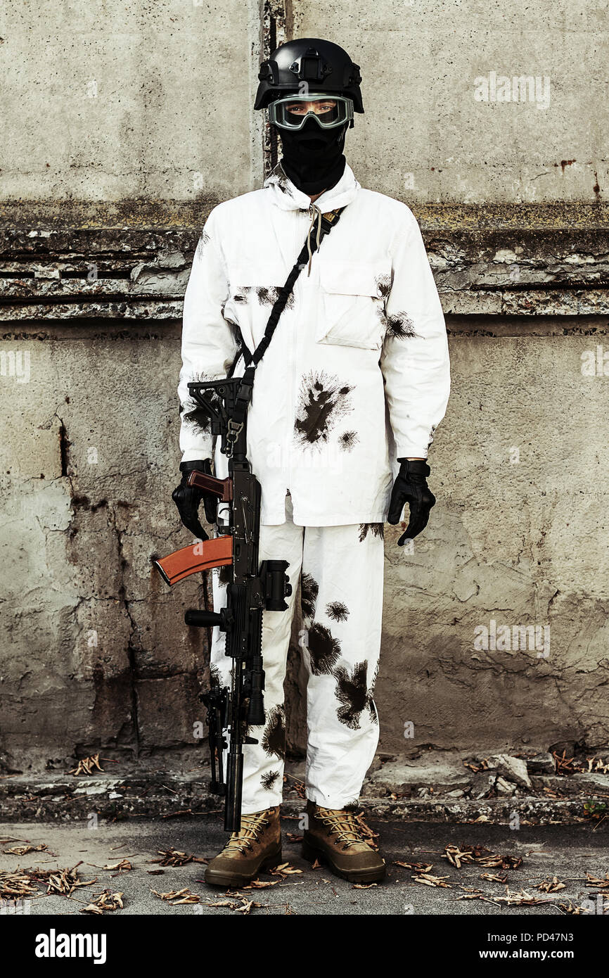 a soldier in the winter camouflage suit armed with AK-47 Stock Photo ...