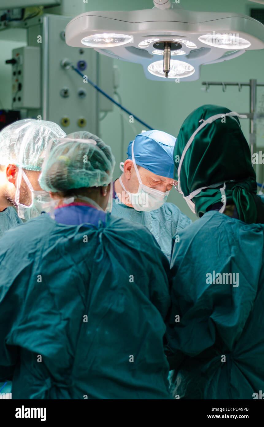 Concentrated doctor, assistant and nurse in a patient during a ...