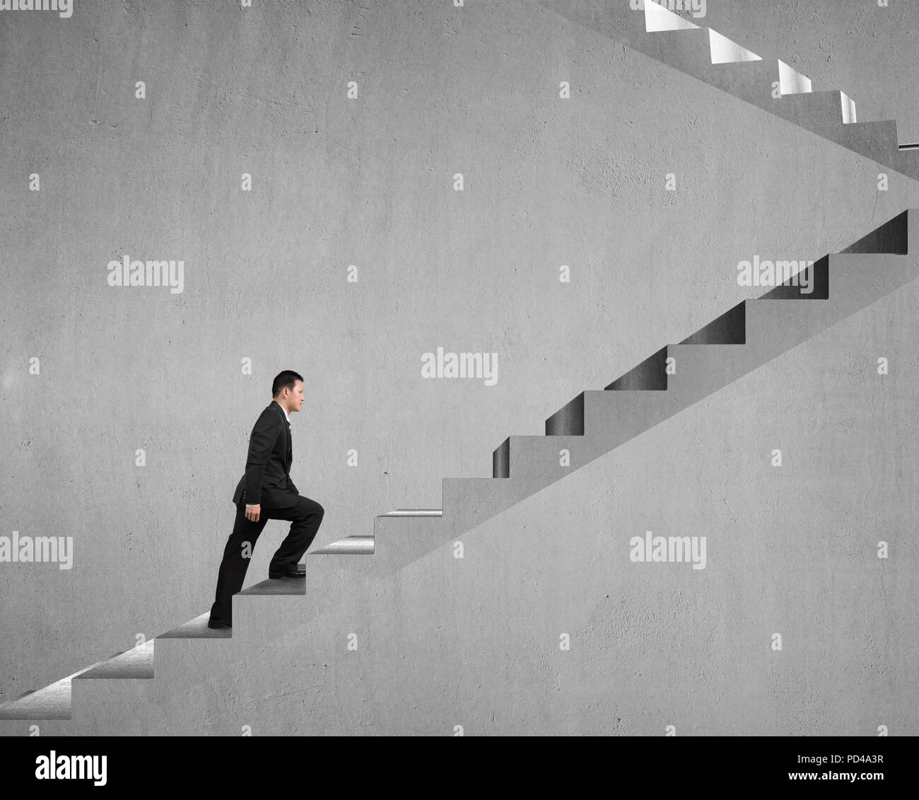 Businessman climbing on concrete stairs with concrete wall background ...