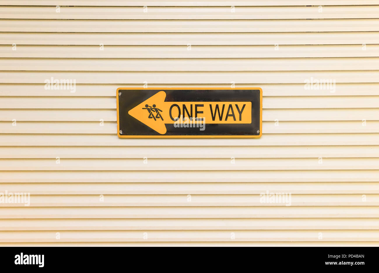 One way sign against a wall background Stock Photo - Alamy