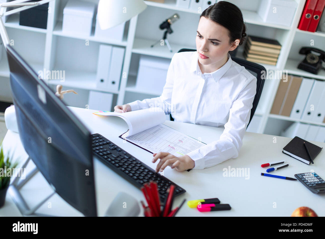 Young girl in the office working with documents at the computer Stock ...