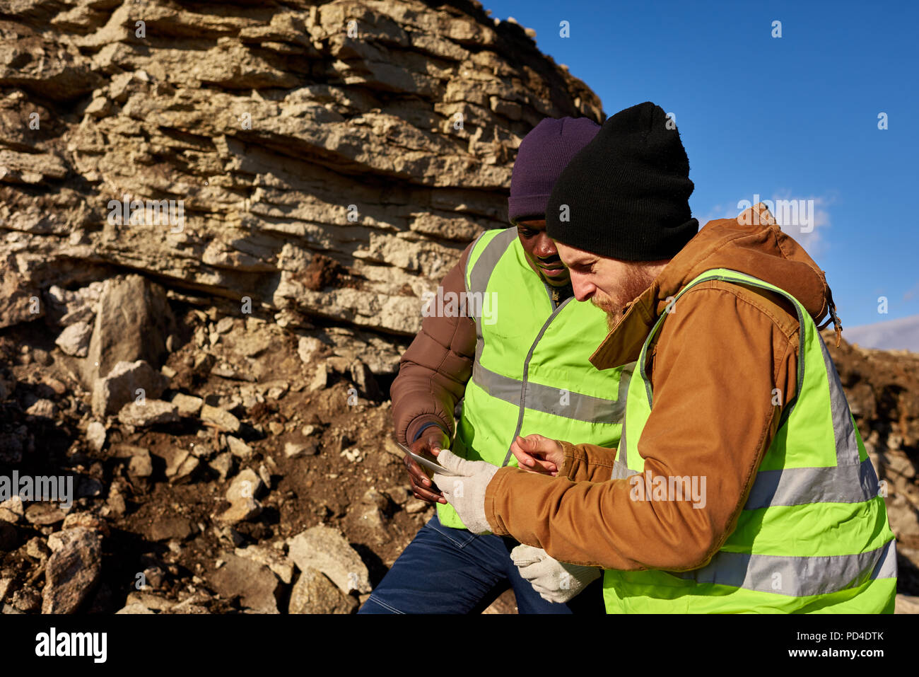 Side view portrait of two industrial workers wearing reflective jackets ...