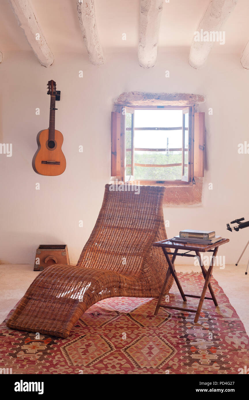 Recliner chair and acoustic guitar on wall Stock Photo - Alamy