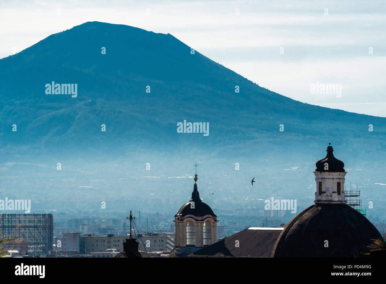 Morning view of Mount Vesuvius over Naples rooftops, dome and spires ...