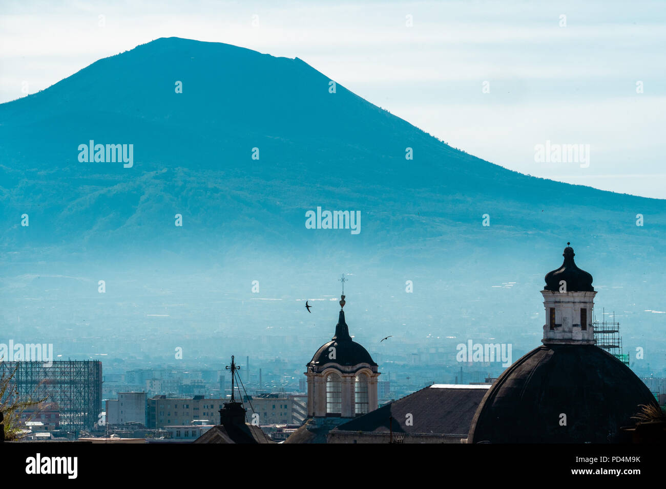 Morning view of Mount Vesuvius over Naples rooftops, dome and spires ...