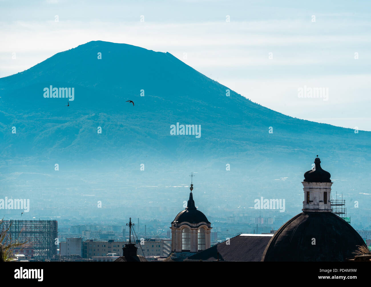 Morning view of Mount Vesuvius over Naples rooftops, dome and spires ...