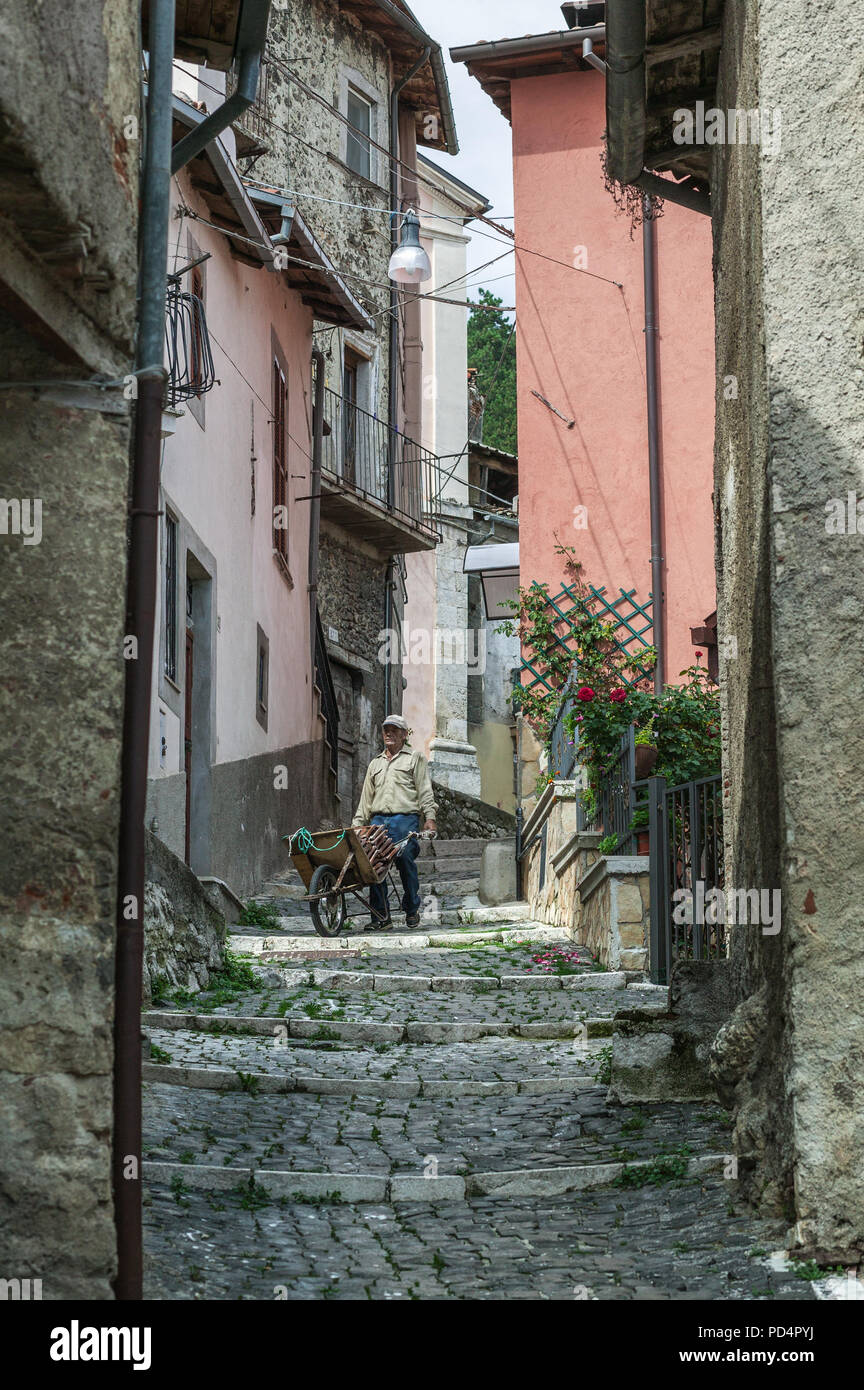 bricklayer with wheelbarrow in narrow alley. Abruzzo Region, Italy ...