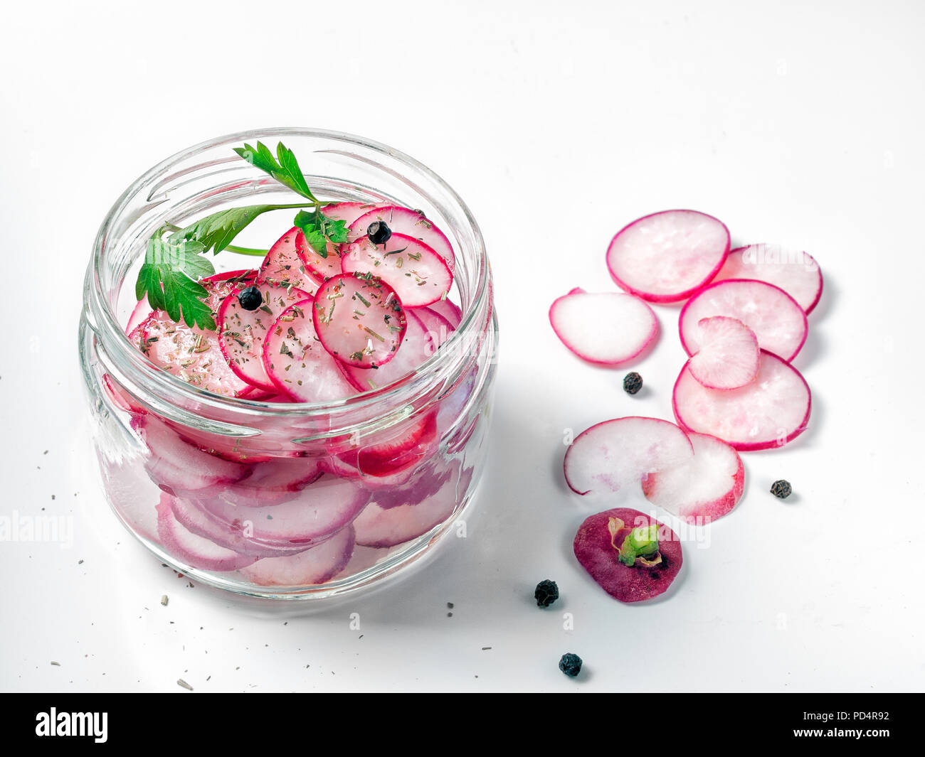 The pink radish is cut into pieces carefully placed in a glass jar with ...