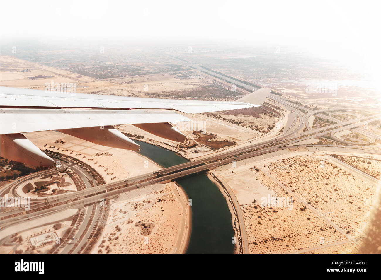 Aerial view out of airplane window down on streets with cars in desert ...