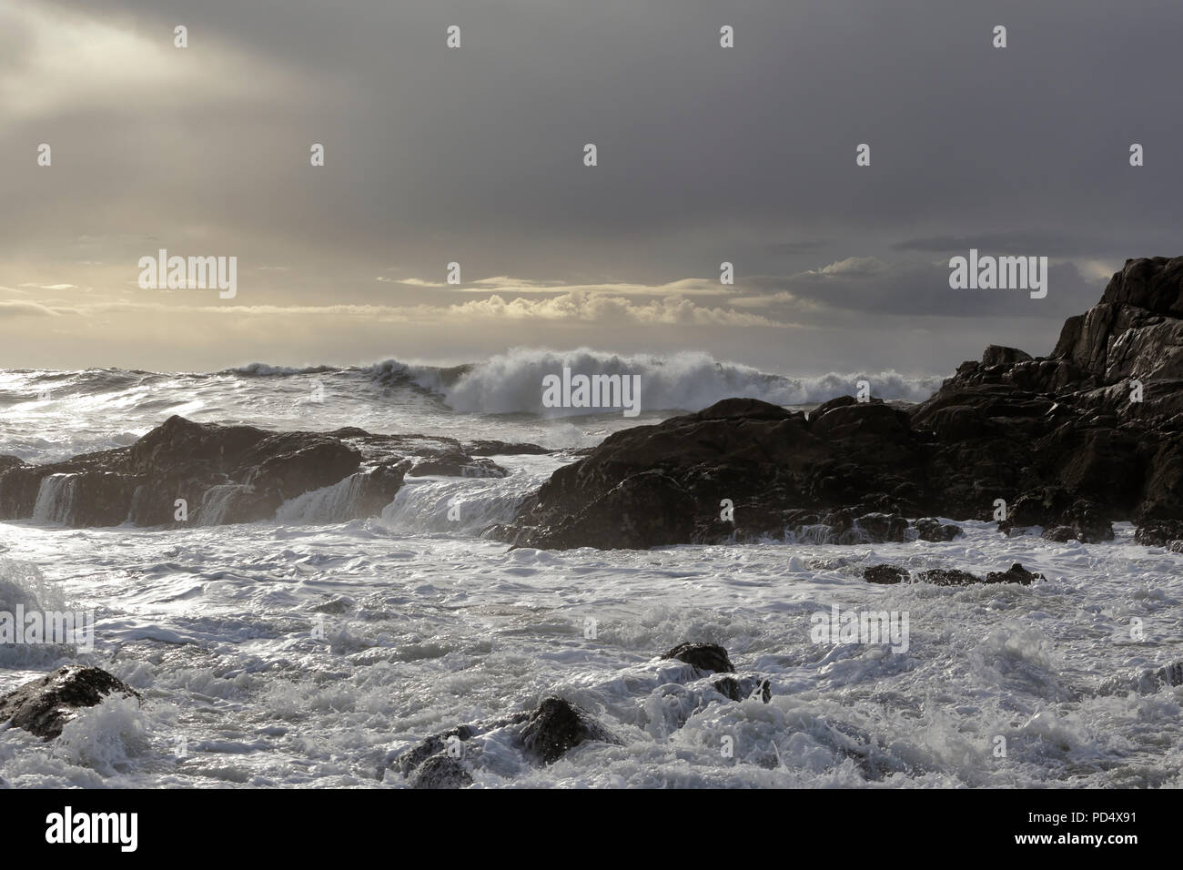 Rocky coast with dramatic dark clouds at sunset hi-res stock ...