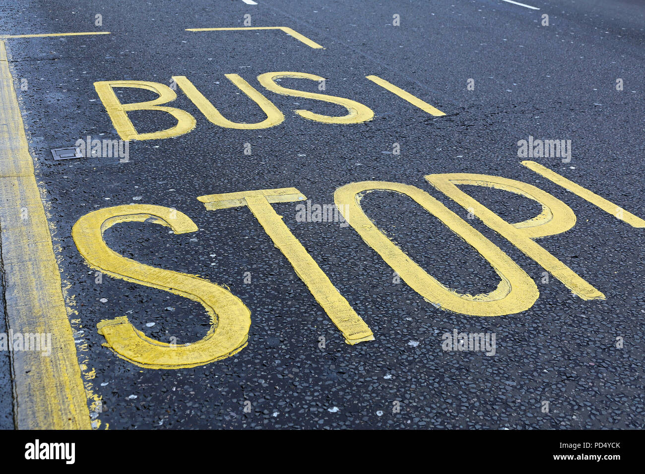 Yellow bus stop sign at asphalt Stock Photo - Alamy