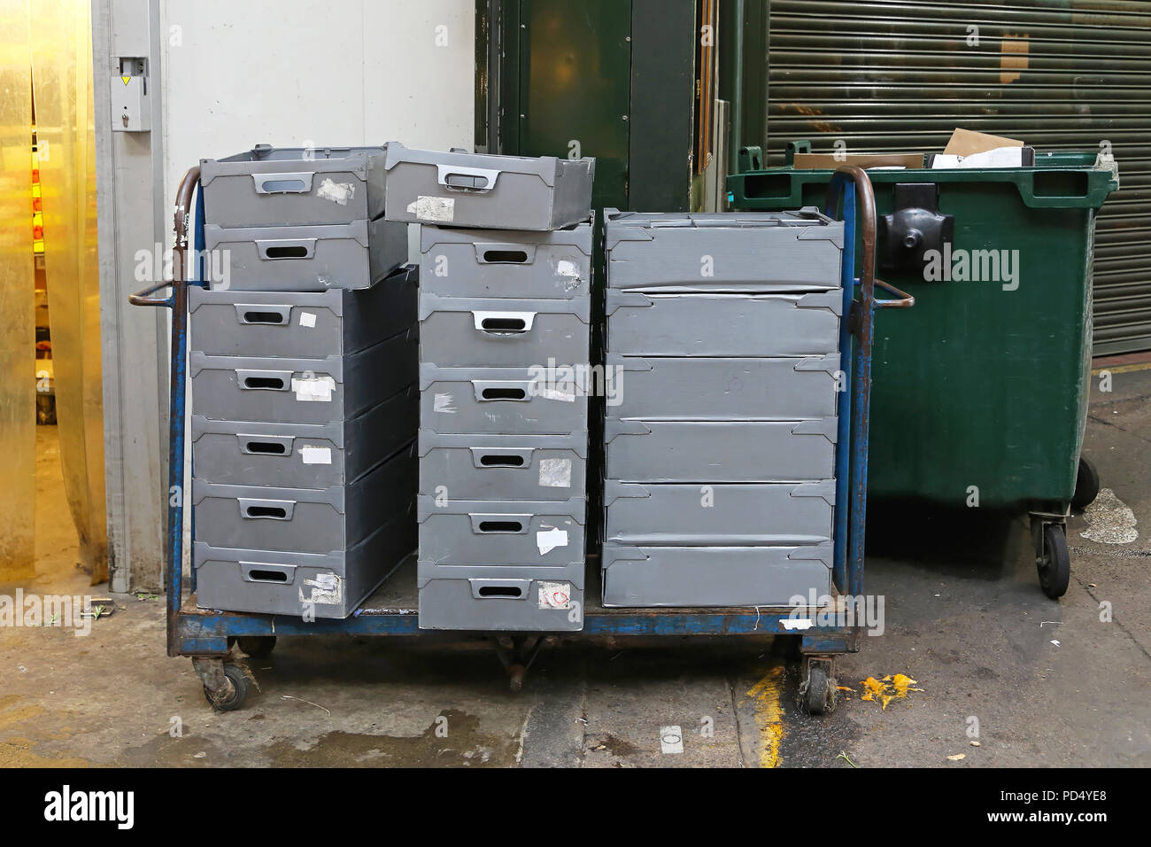 Delivery cart with plastic crates at back entrance Stock Photo - Alamy