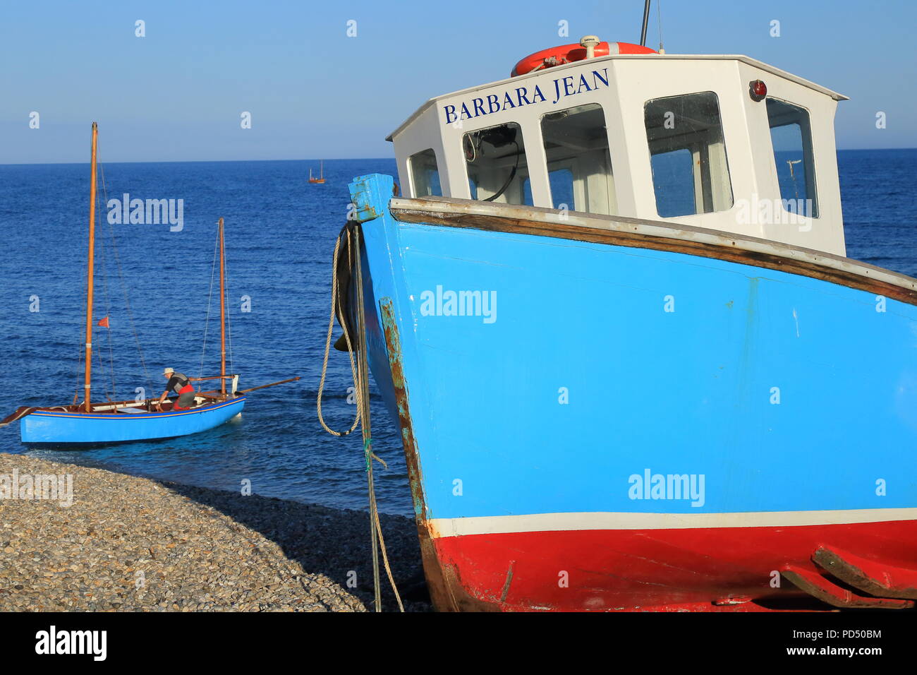 Old fishing boat on the pebble beach in village of Beer in Devon Stock ...