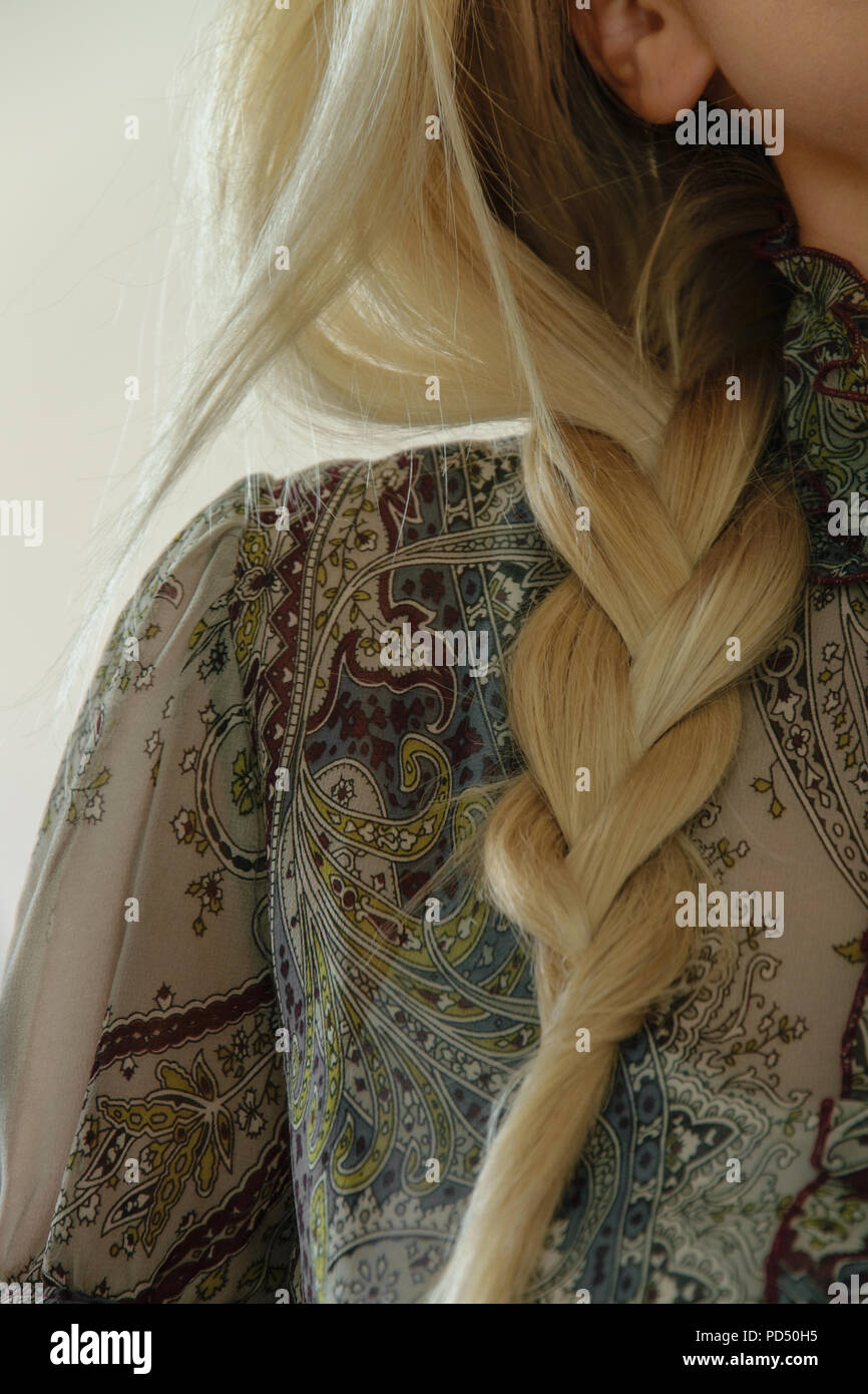 Concept of stylish hairstyle. Close-up of a blond woman with braid hair ...