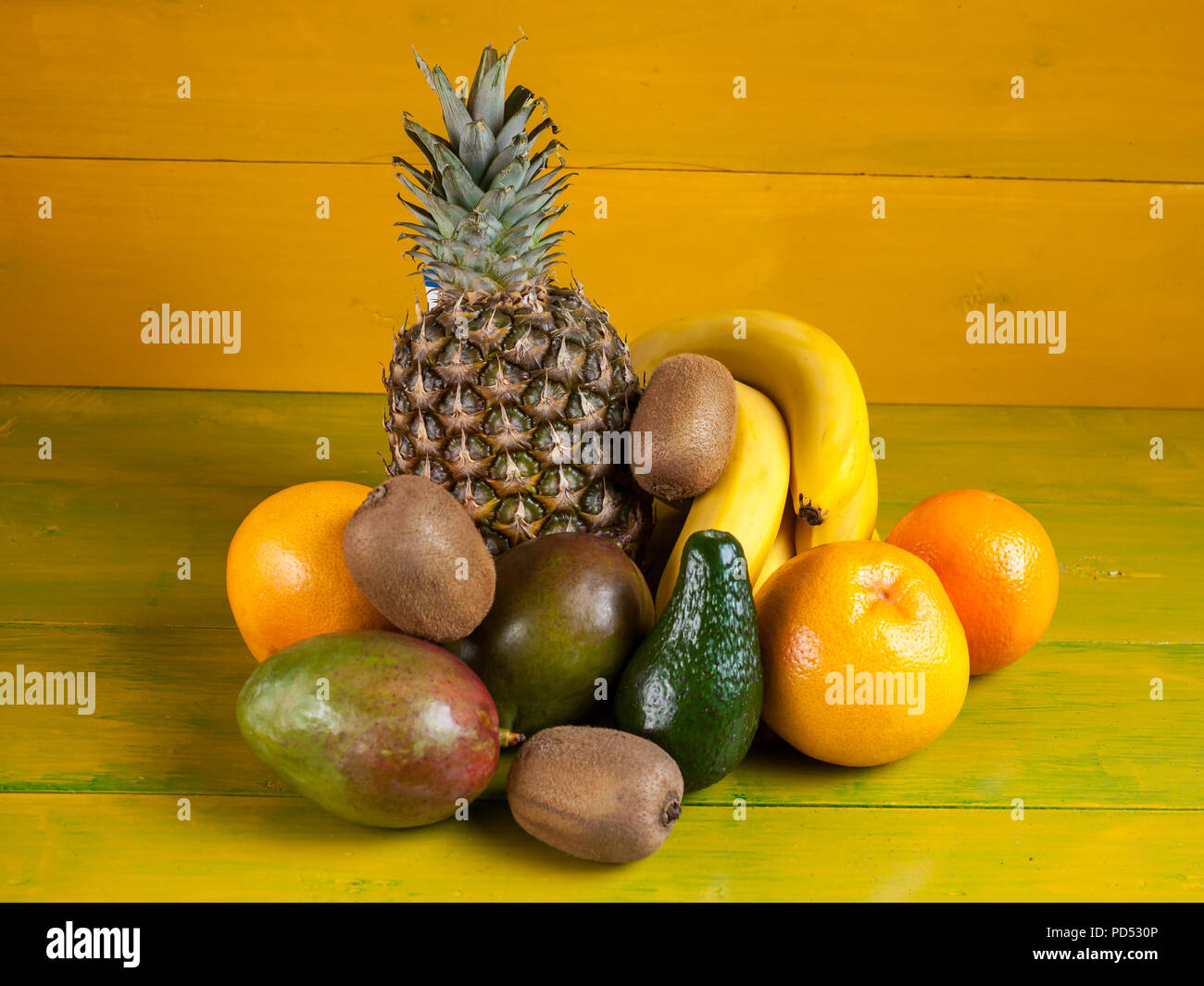 Tropical fruit on yellow wooden background, fresh food Stock Photo - Alamy