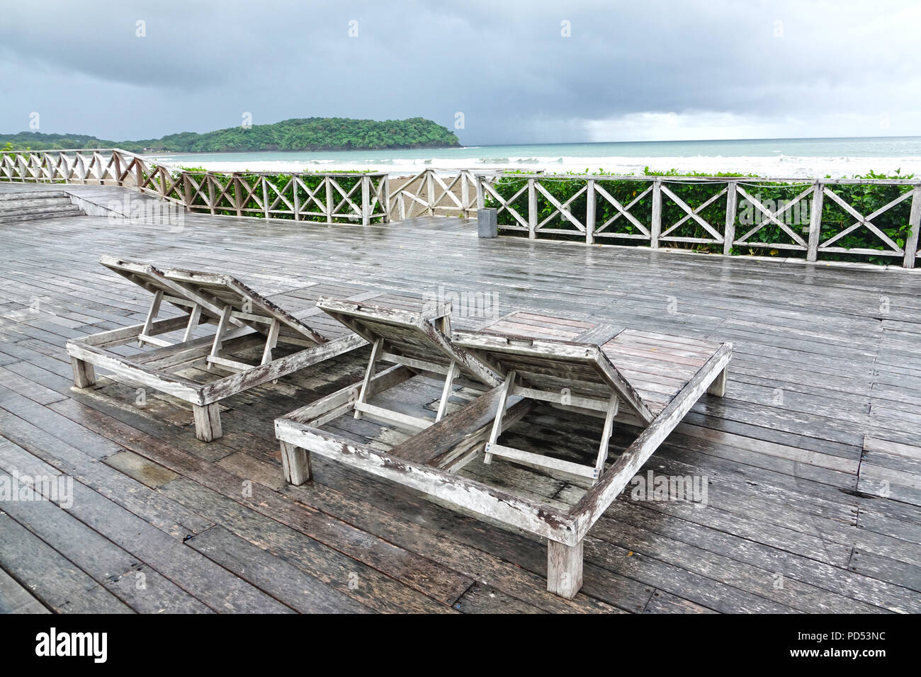 Wood deck with chairs in a tropical beach looking towards the Pacific ...
