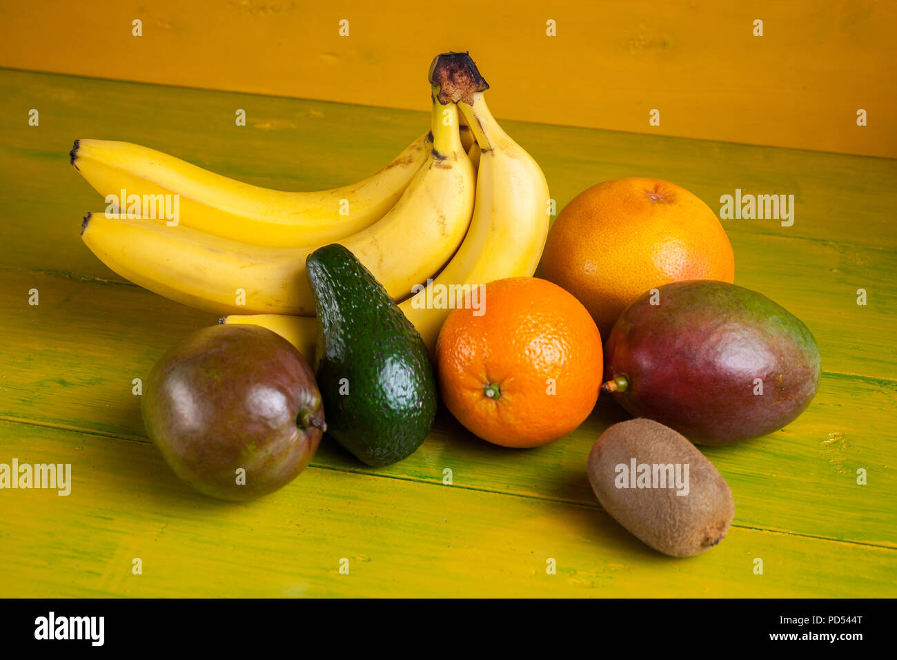 Tropical fruit on yellow wooden background, fresh food Stock Photo - Alamy